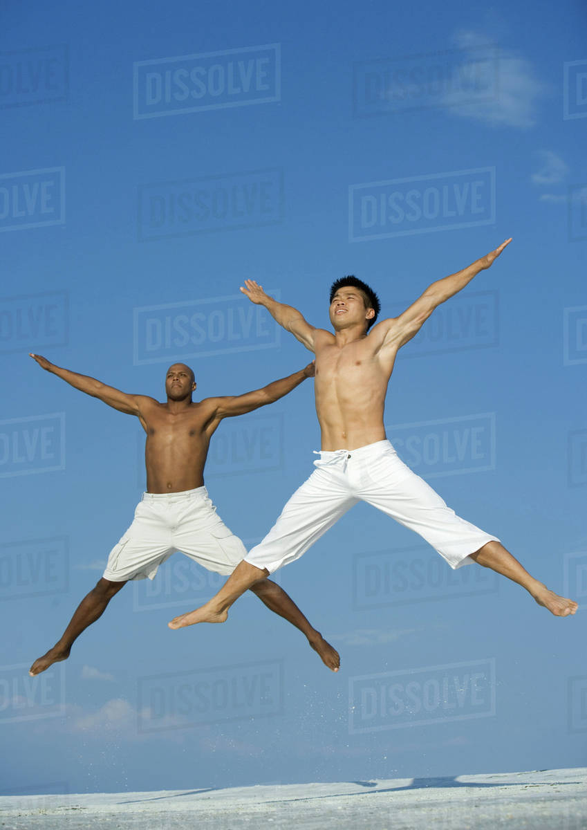 Two men jumping in the air with arms and legs out - Royalty-free Stock ...