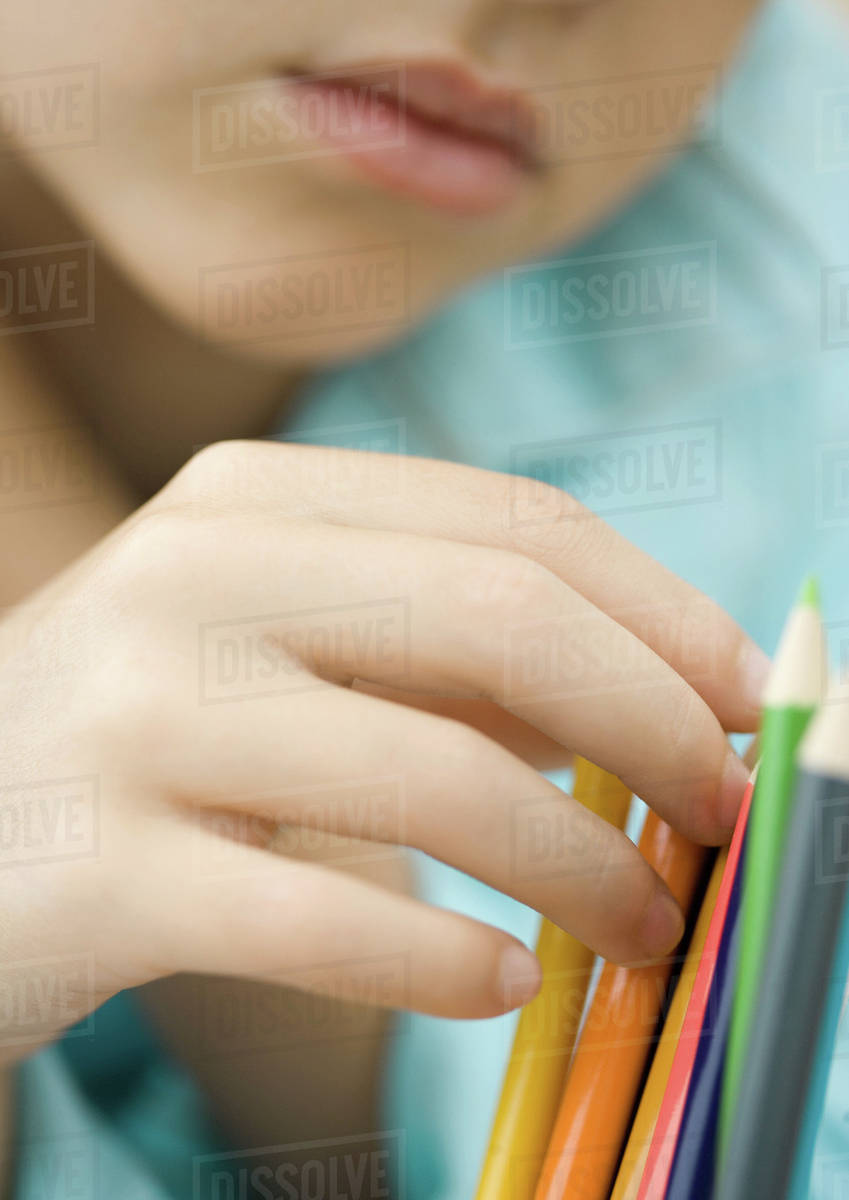 Child touching colored pencils - Royalty-free Stock Photo | Dissolve