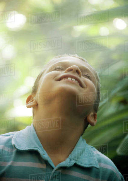 Boy smiling with head back in mist - Royalty-free Stock Photo | Dissolve