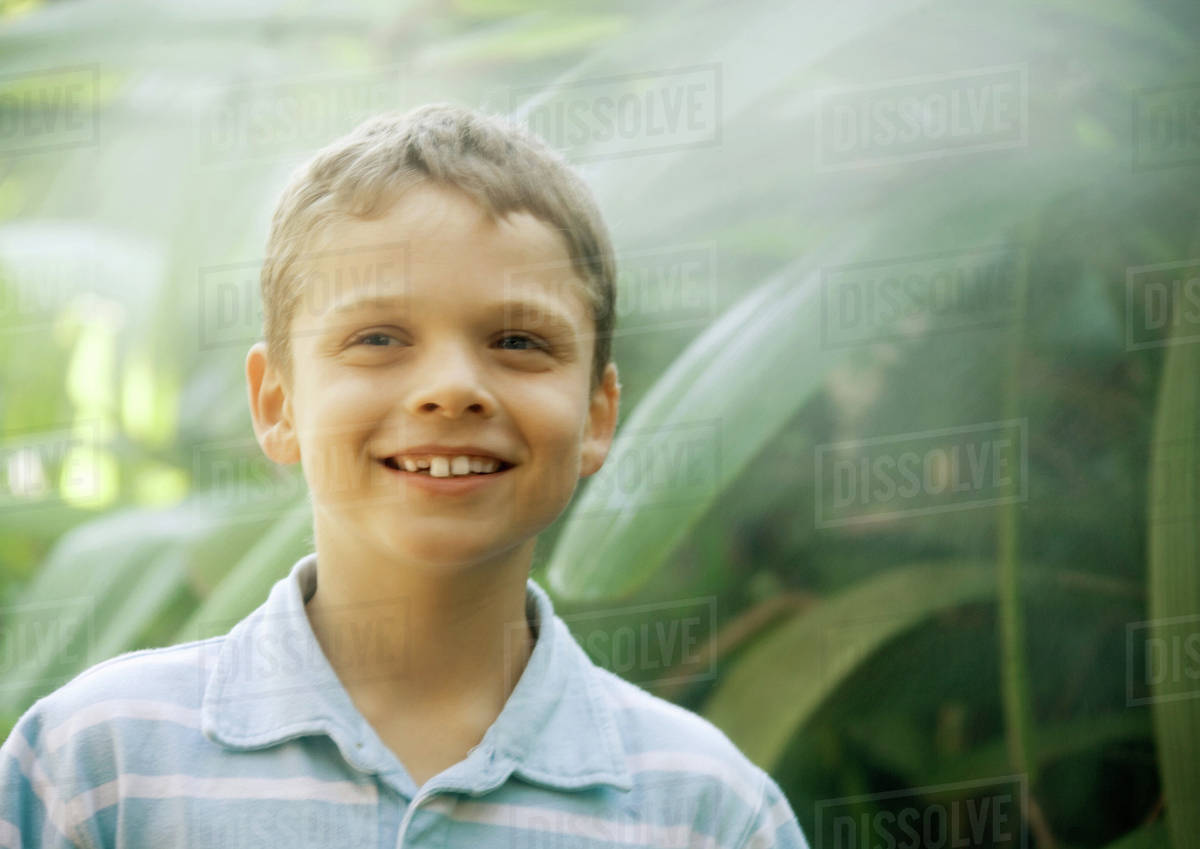 Boy standing in mist, smiling - Stock Photo - Dissolve