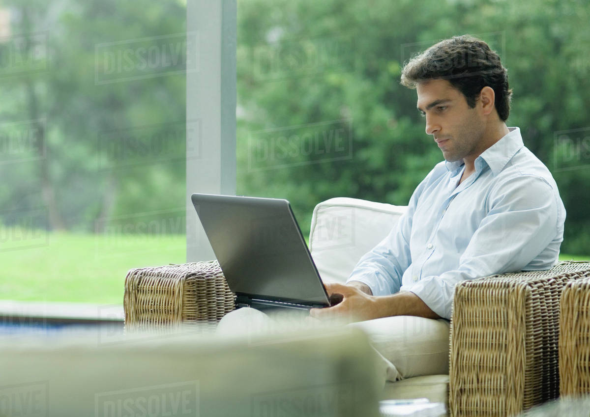 Casually dressed young executive working on laptop outdoors - Royalty ...