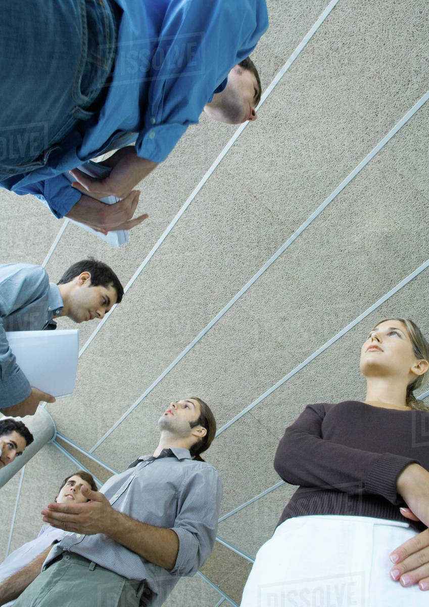 Group of young business people speaking, low angle view - Royalty-free ...