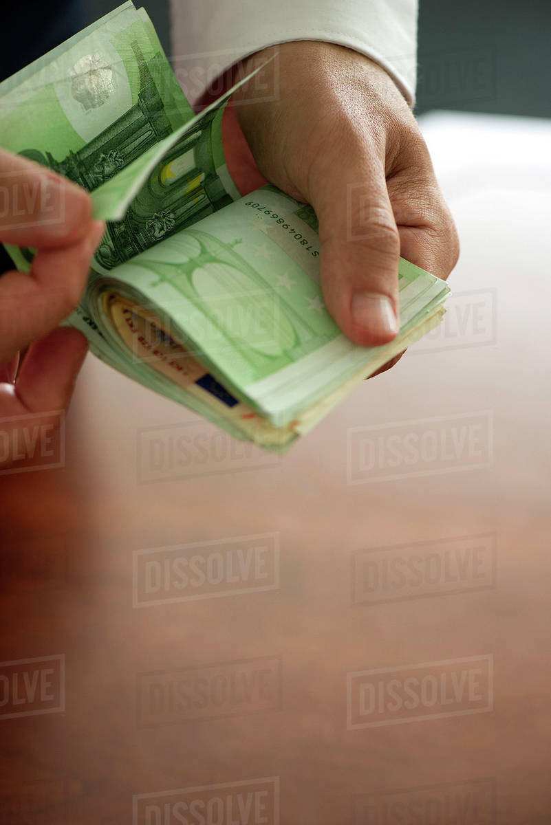 Man counting stack of money, cropped - Royalty-free Stock Photo | Dissolve