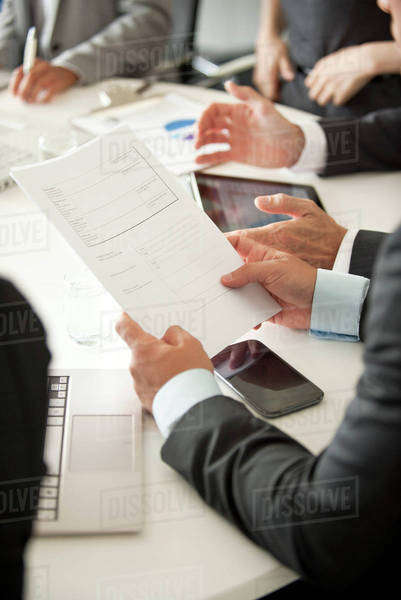 Businessman at meeting reviewing document - Royalty-free Stock Photo ...