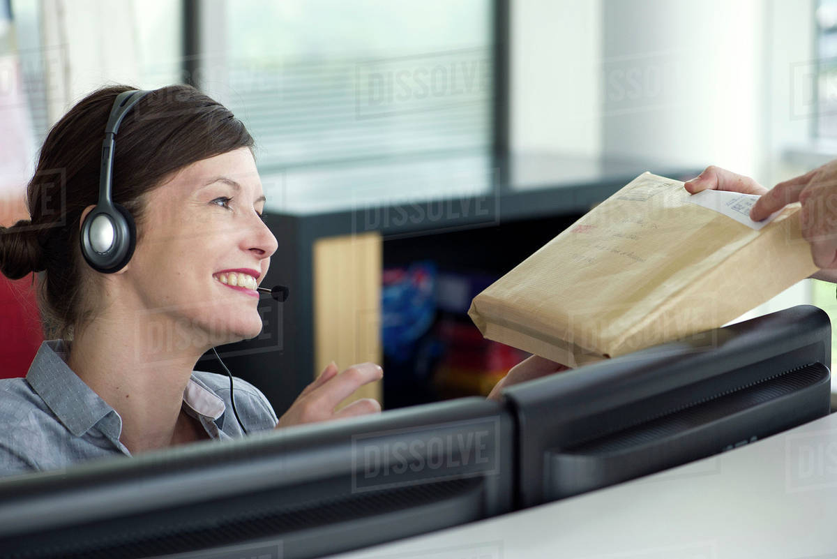 Receptionist accepting package from delivery person - Royalty-free ...