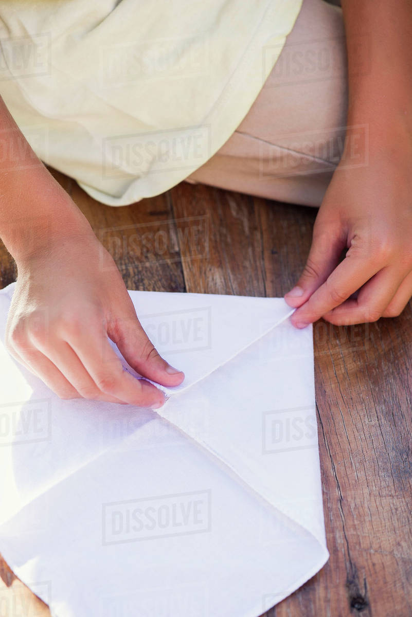 Child folding paper, cropped - Royalty-free Stock Photo | Dissolve