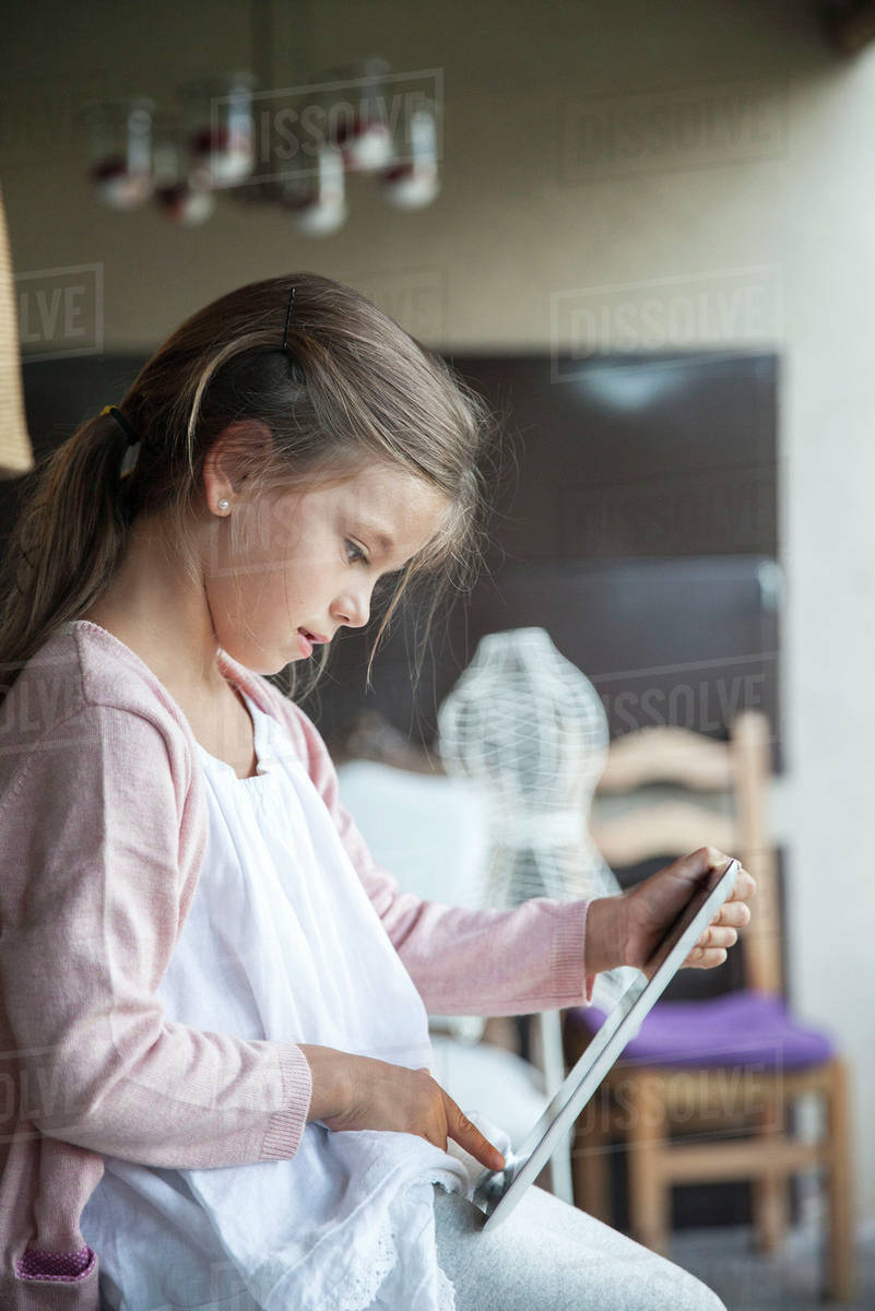 Little girl using digital tablet - Royalty-free Stock Photo | Dissolve