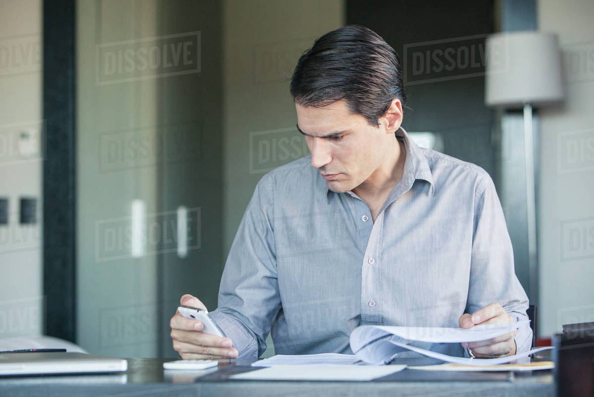 Businessman checking smartphone in office - Royalty-free Stock Photo ...