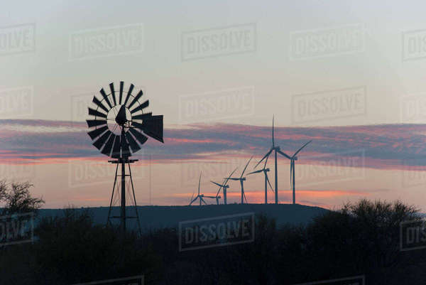 Tranquil view of an old-fashioned windmill and modern wind turbines ...