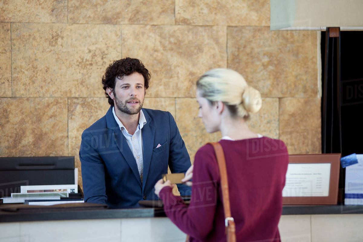 Hotel receptionist assisting guest - Royalty-free Stock Photo | Dissolve