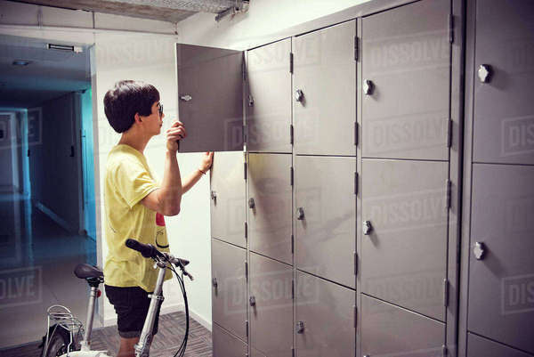 College student opening locker in corridor - Stock Photo - Dissolve