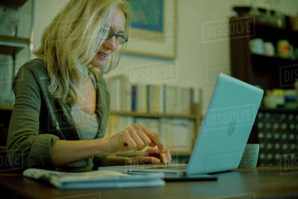 Woman using laptop computer - Stock Photo - Dissolve