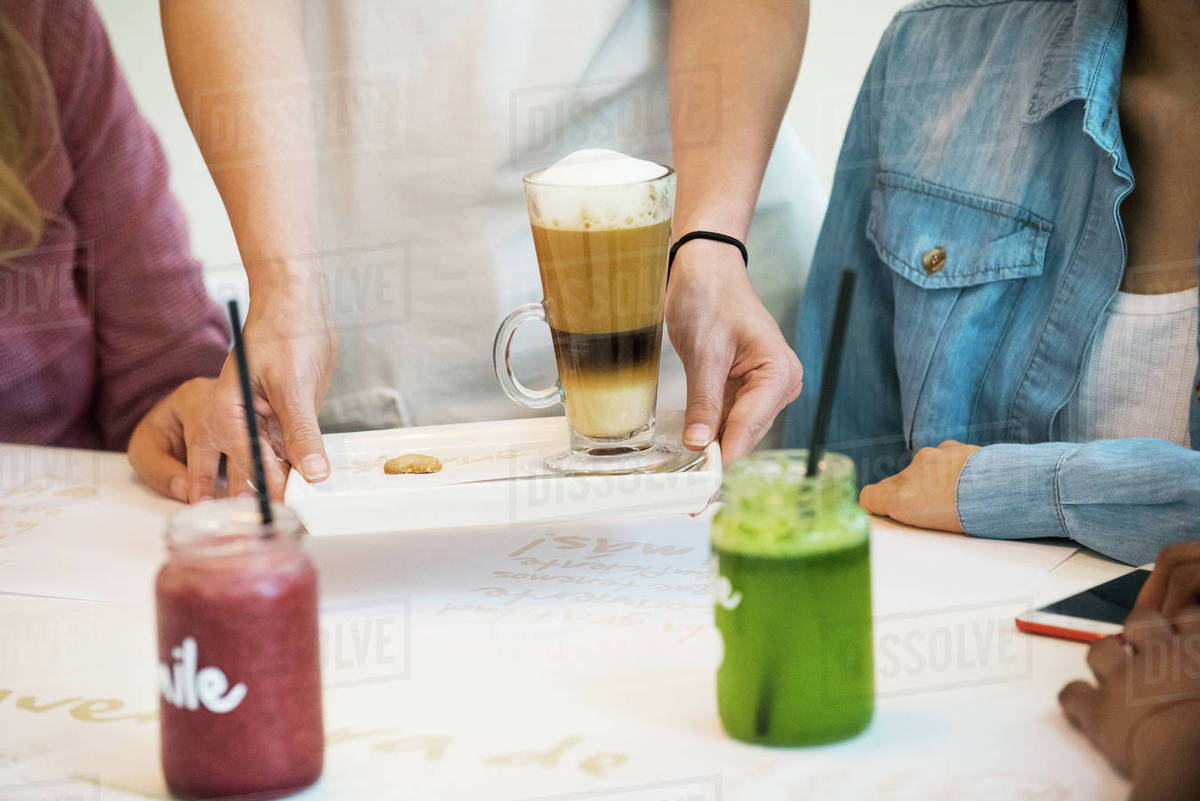 Waitress serving drinks in cafe, cropped - Stock Photo - Dissolve