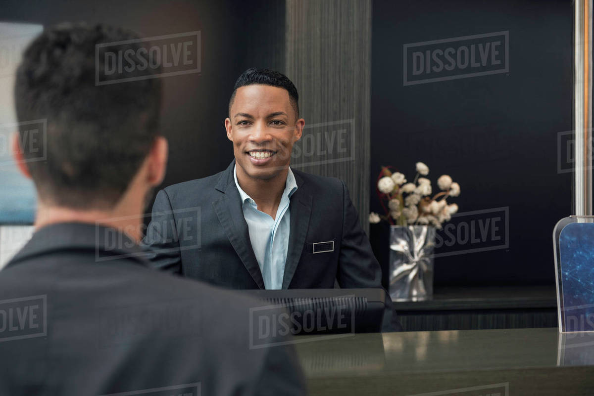 Hotel receptionist greeting customer - Royalty-free Stock Photo | Dissolve