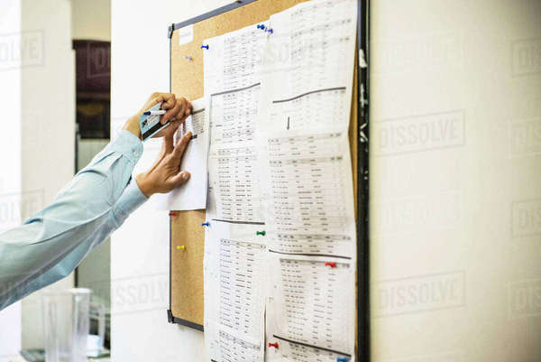 Woman pinning document on office bulletin board - Royalty-free Stock ...