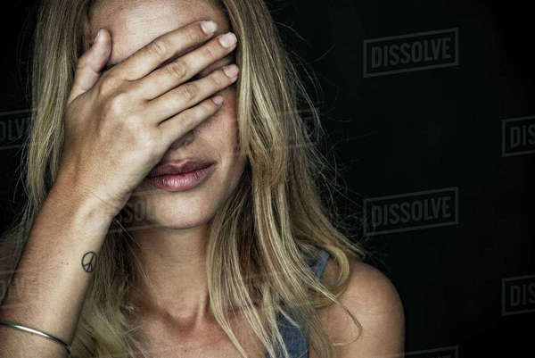 Woman covering face with hand - Royalty-free Stock Photo | Dissolve