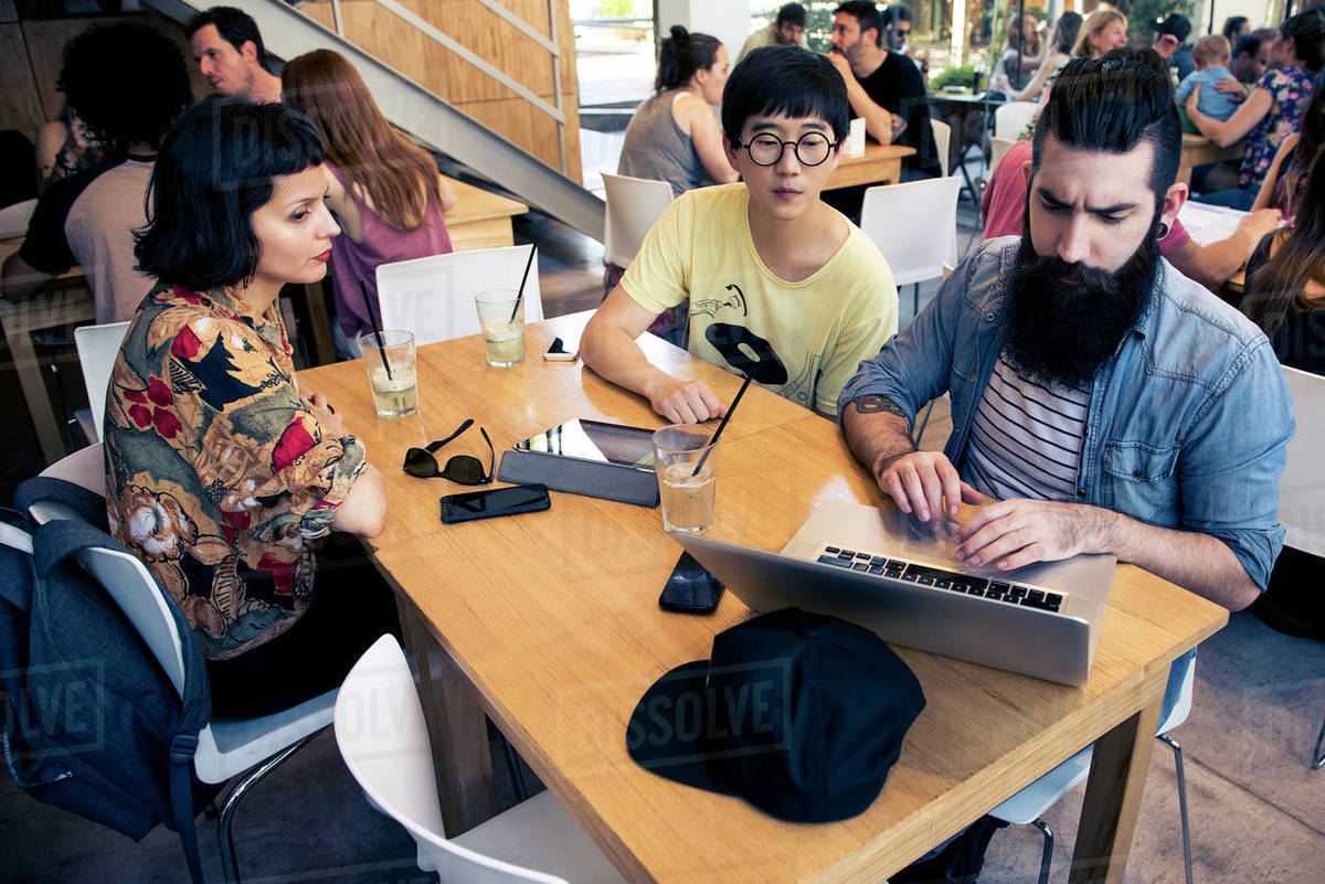 Man using laptop computer while companions watch - Royalty-free Stock ...