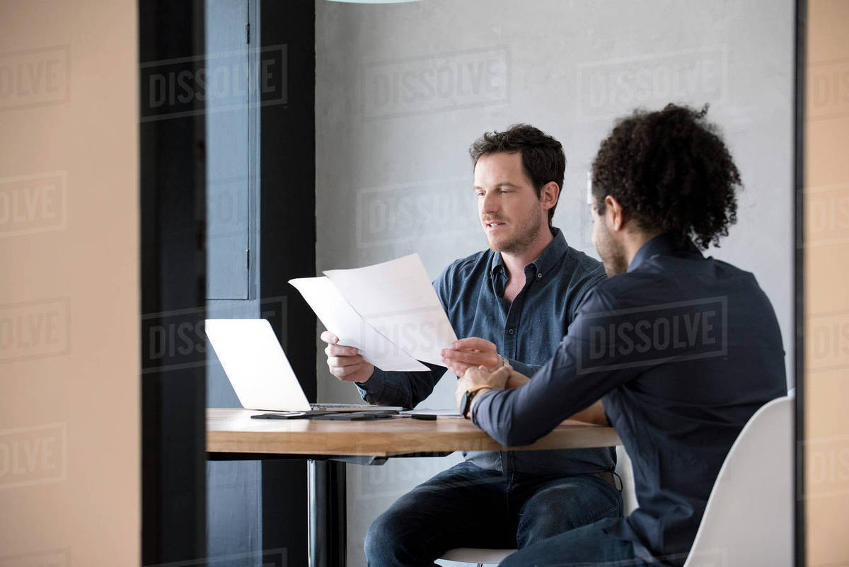 Men in office reviewing document - Royalty-free Stock Photo | Dissolve