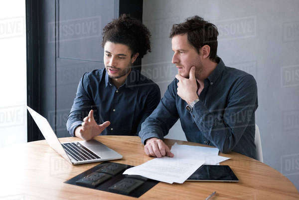 Men using laptop computer together - Royalty-free Stock Photo | Dissolve