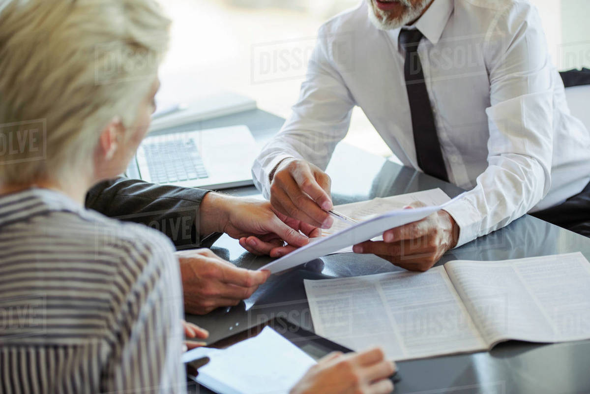 Businessman explaining document to colleagues - Stock Photo - Dissolve