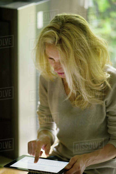 Woman using digital tablet at home - Royalty-free Stock Photo | Dissolve