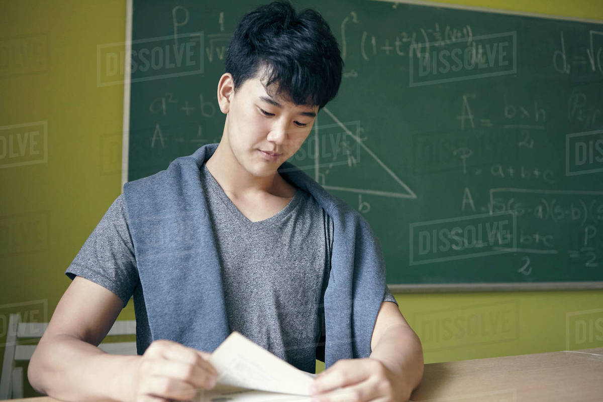 Young man studying in math class - Stock Photo - Dissolve