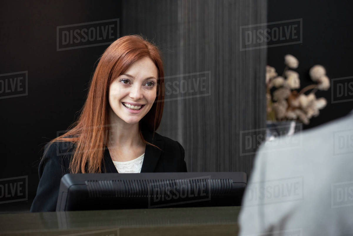 Female receptionist looking at businessman - Royalty-free Stock Photo ...