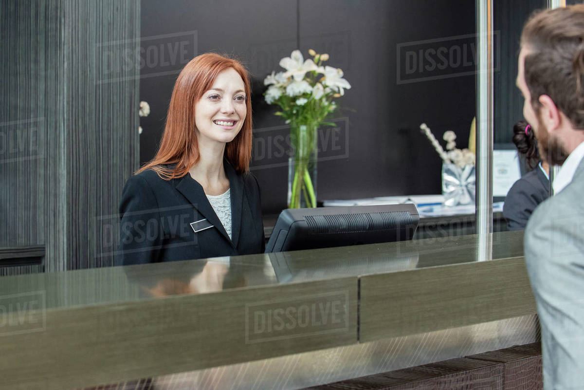 Female receptionist looking at businessman - Royalty-free Stock Photo ...