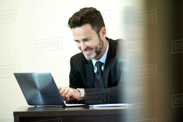 Businessman using laptop in office - Royalty-free Stock Photo | Dissolve