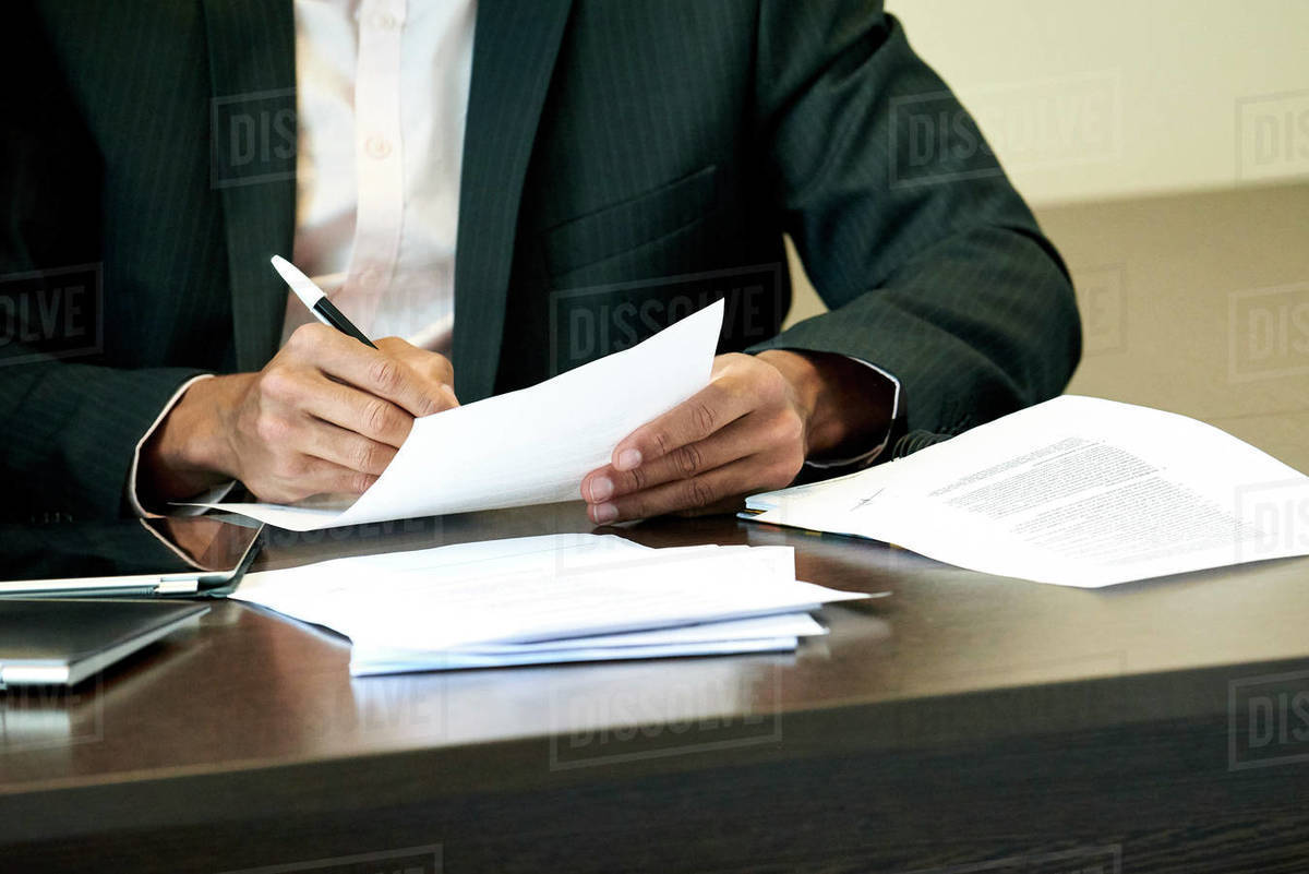 Businessman checking a document on his desk - Royalty-free Stock Photo ...