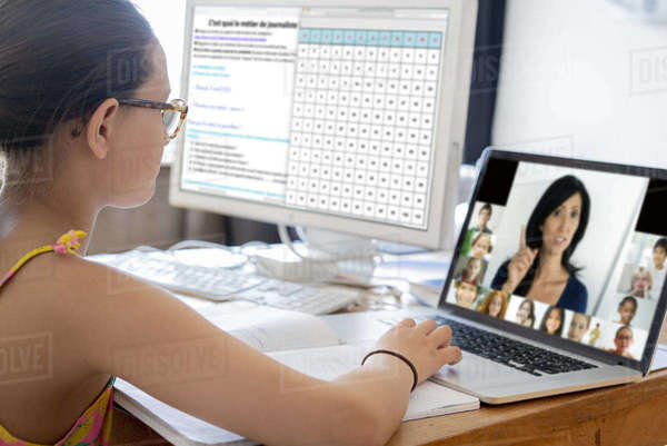 Girl attending online school classes from home - Stock Photo - Dissolve