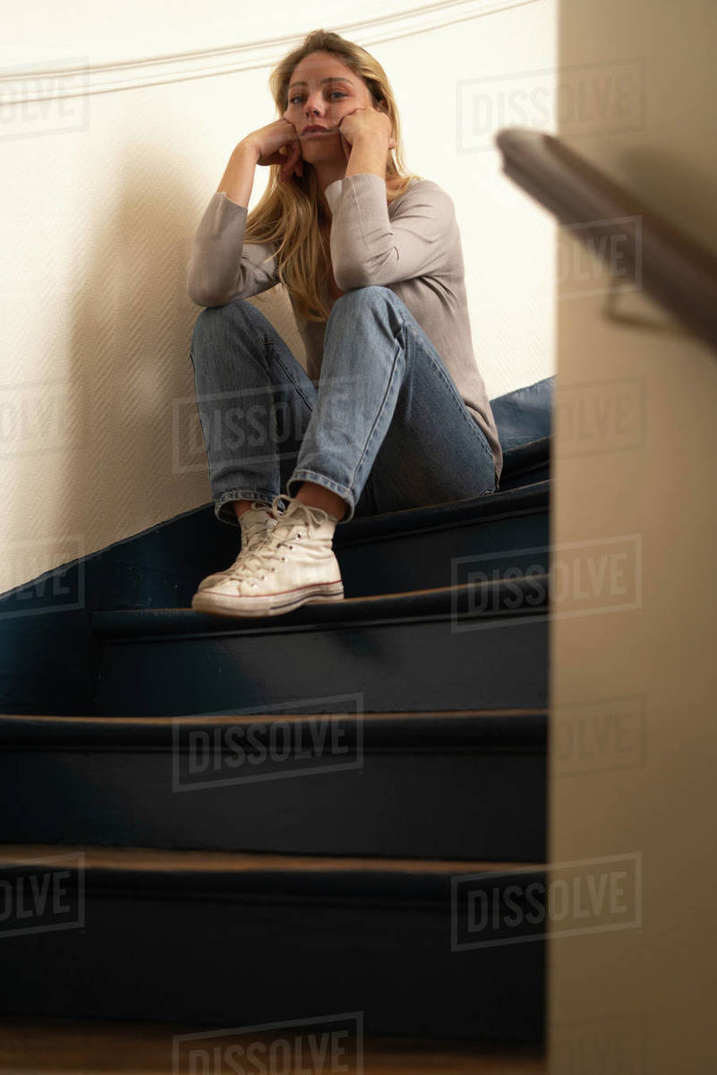 Young woman sitting on steps - Royalty-free Stock Photo | Dissolve