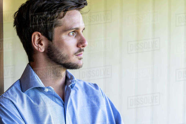 Portrait of young man standing in house - Royalty-free Stock Photo ...