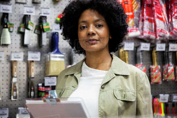 African American female hardware shop owner looking at the camera while ...