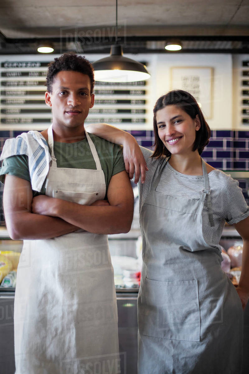Cheerful grocery store owners standing in front of refrigerator - Stock ...