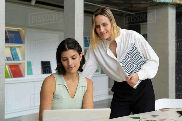 Mid-shot of female interior designer and her female Latin-American ...