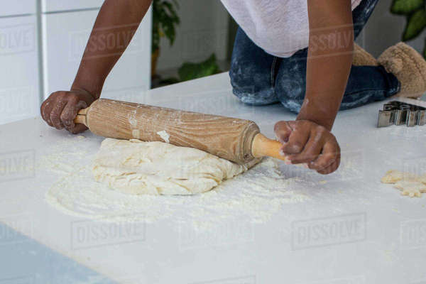 Girl rolling dough in kitchen - Royalty-free Stock Photo | Dissolve