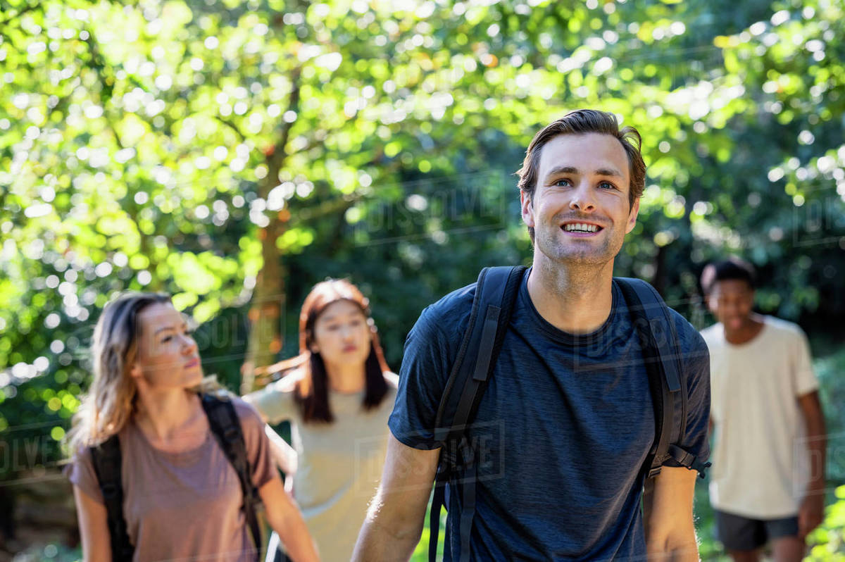 Young adult man having fun during hiking excursion with friends ...