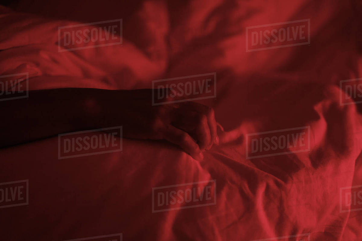 Unidentified person's hand in bed under red light - Royalty-free Stock ...