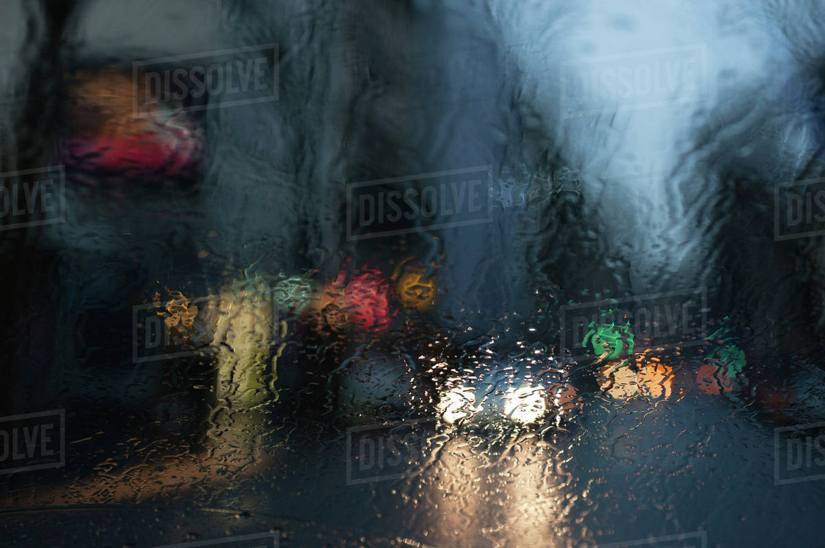 City street viewed through rain covered window - Stock Photo - Dissolve