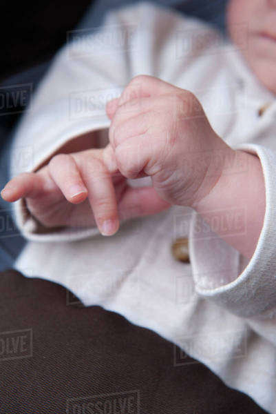 Baby pulling fingers, cropped - Royalty-free Stock Photo | Dissolve