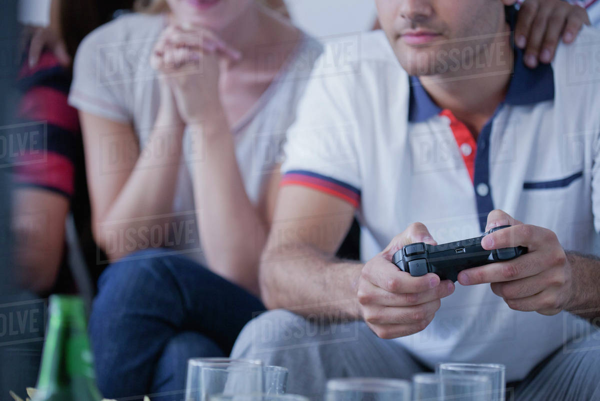 Young man playing video game while friend watches - Royalty-free Stock ...