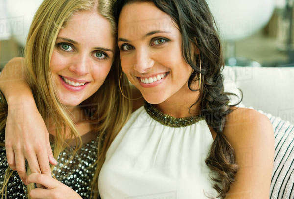 Portrait of smiling women hugging - Stock Photo - Dissolve