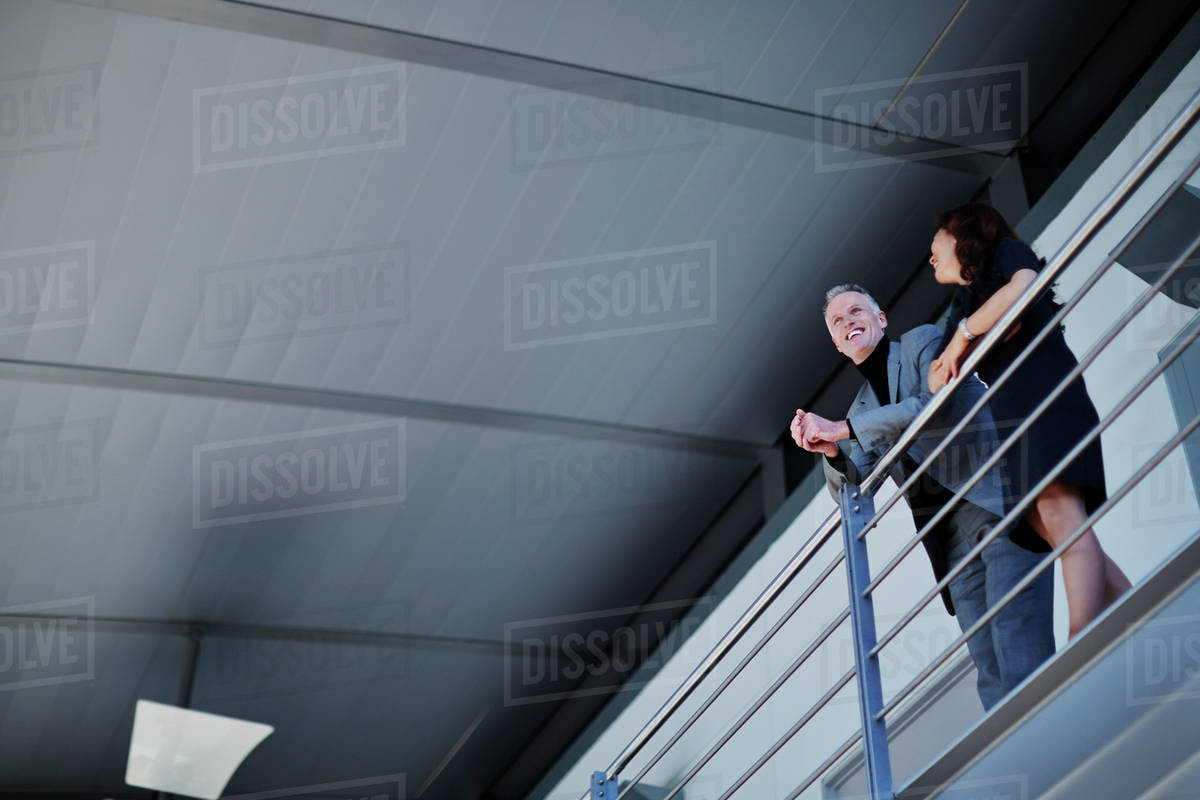 Business people talking at railing - Royalty-free Stock Photo | Dissolve