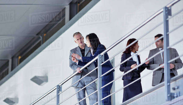 Business people talking at railing n office - Royalty-free Stock Photo ...
