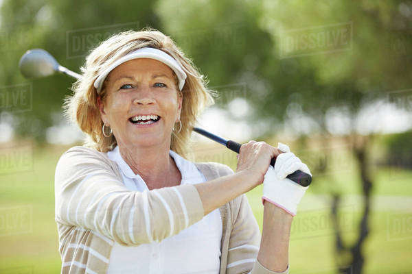 Senior woman playing golf on course - Royalty-free Stock Photo | Dissolve