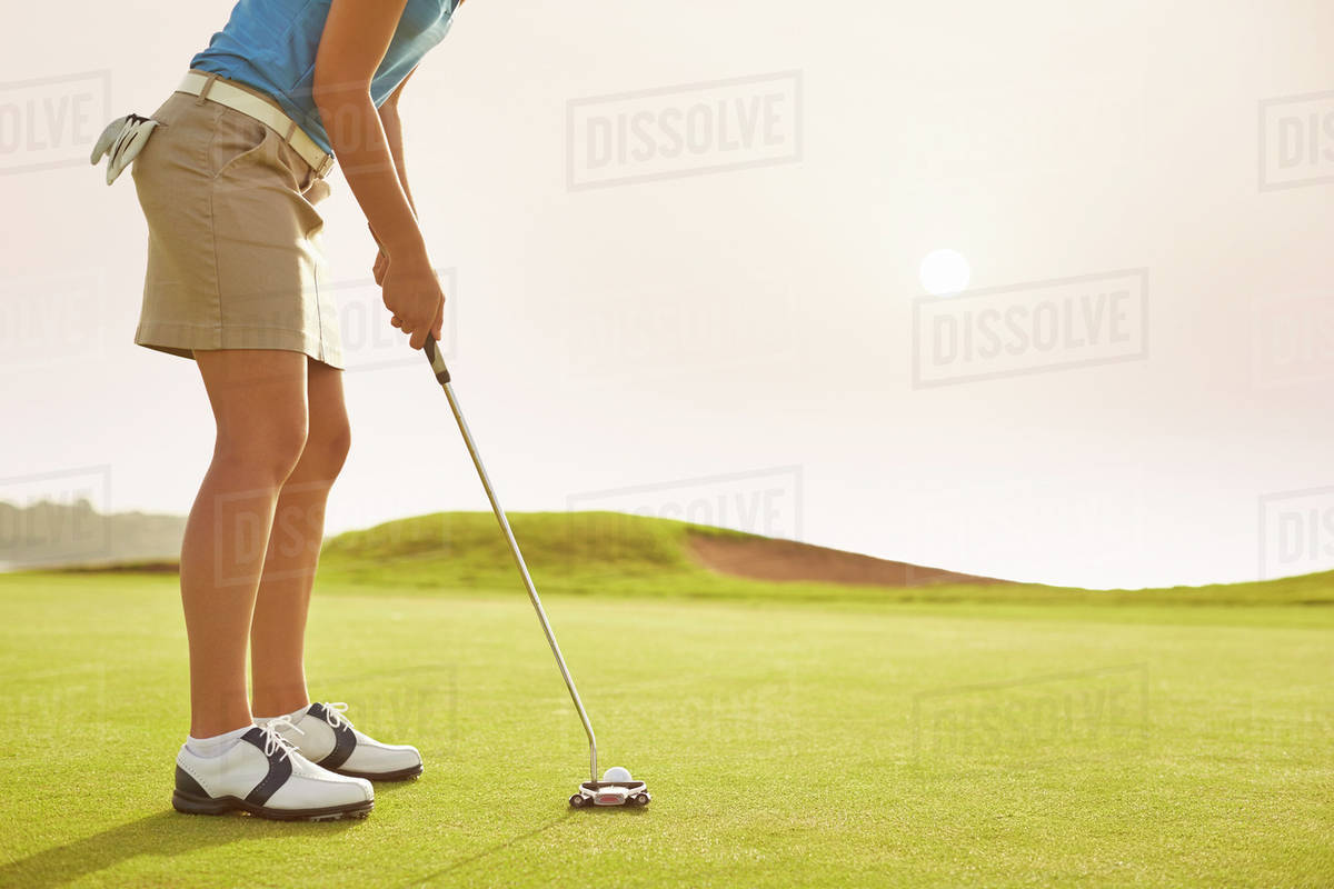 Woman putting on golf course - Royalty-free Stock Photo | Dissolve