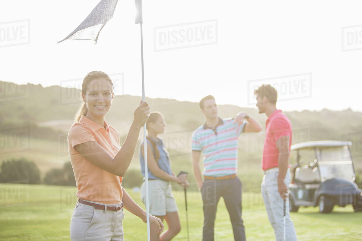 Smiling friends on golf course - Royalty-free Stock Photo | Dissolve
