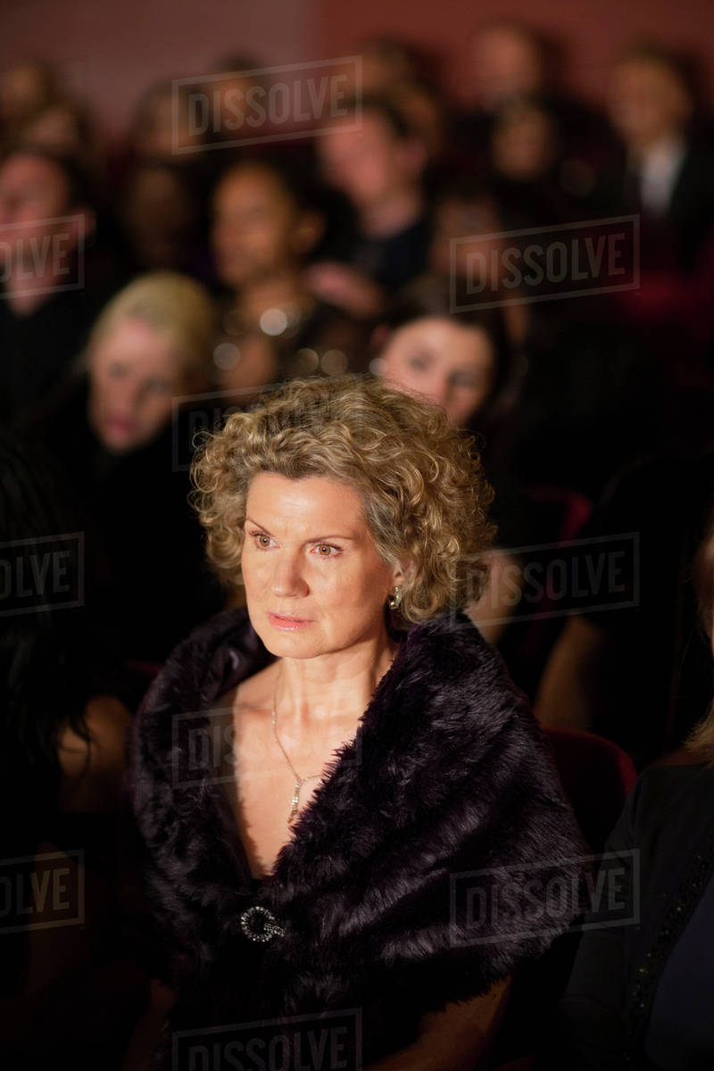 Serious woman in theater audience - Stock Photo - Dissolve