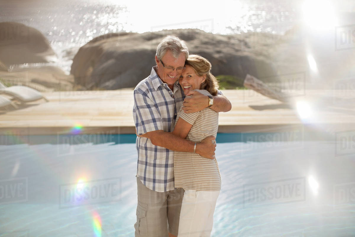 Older couple hugging by pool - Royalty-free Stock Photo | Dissolve